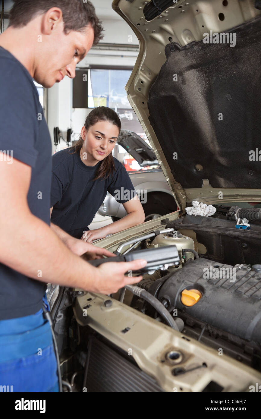 Two mechanic workers with diagnostics tool Stock Photo - Alamy