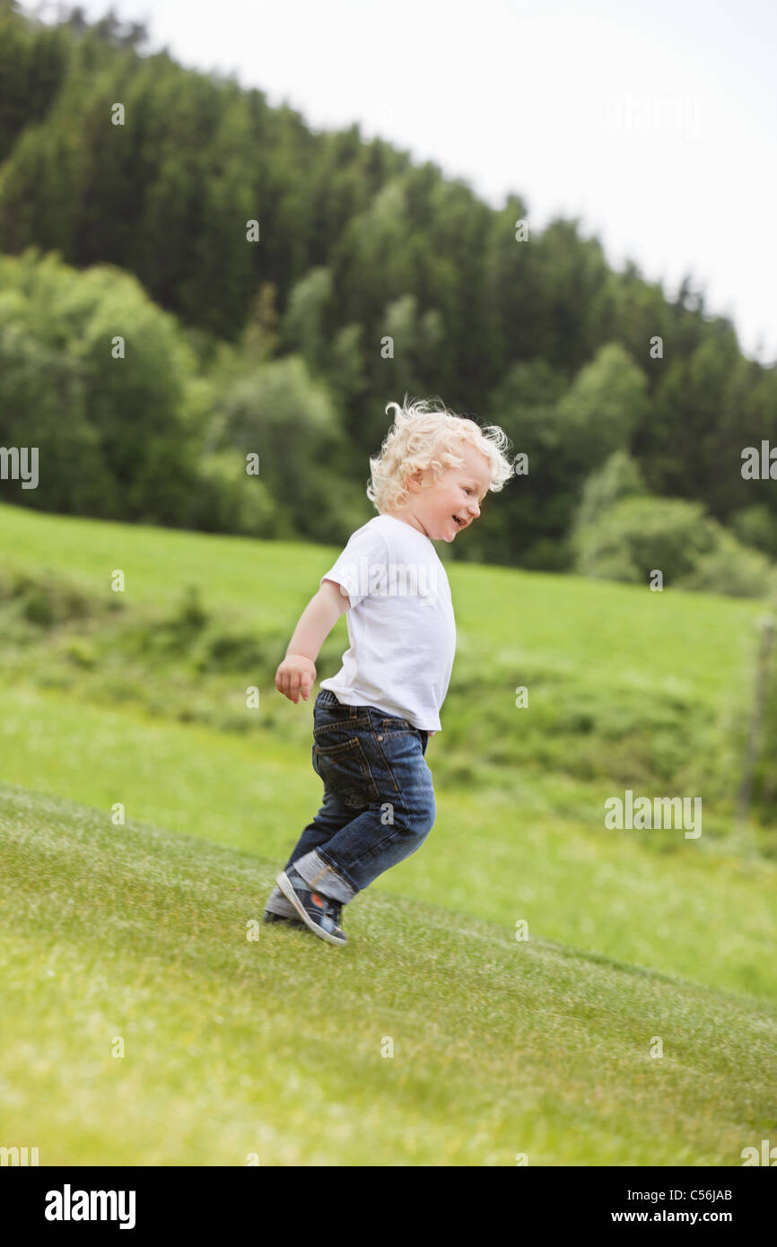 Full length of cheerful cute boy walking in garden Stock Photo - Alamy