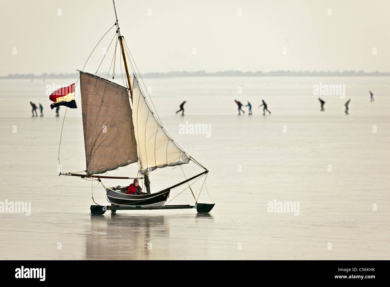 The Netherlands, Monnickendam. People ice skating and ice sailing boat ...