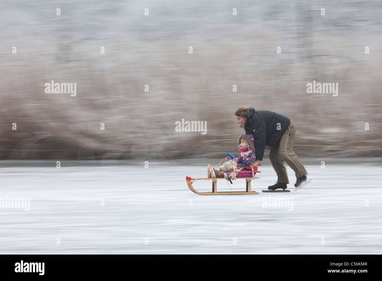 The Netherlands, Ankeveen. Mother and daughter on sledge ice skating ...