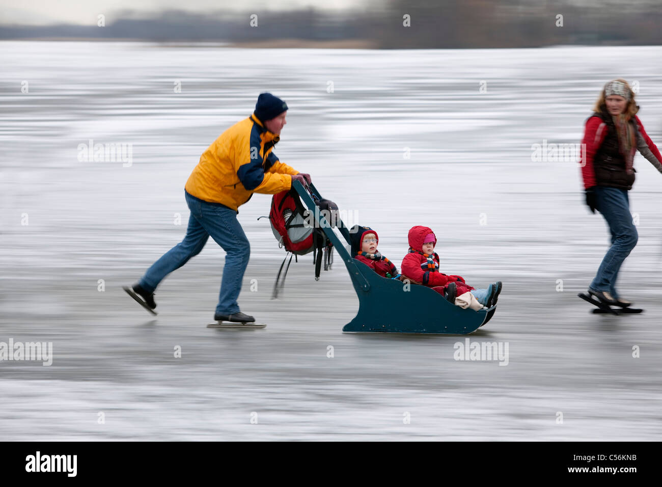 The Netherlands, Ankeveen. Family with sledge ice skating. Motion ...