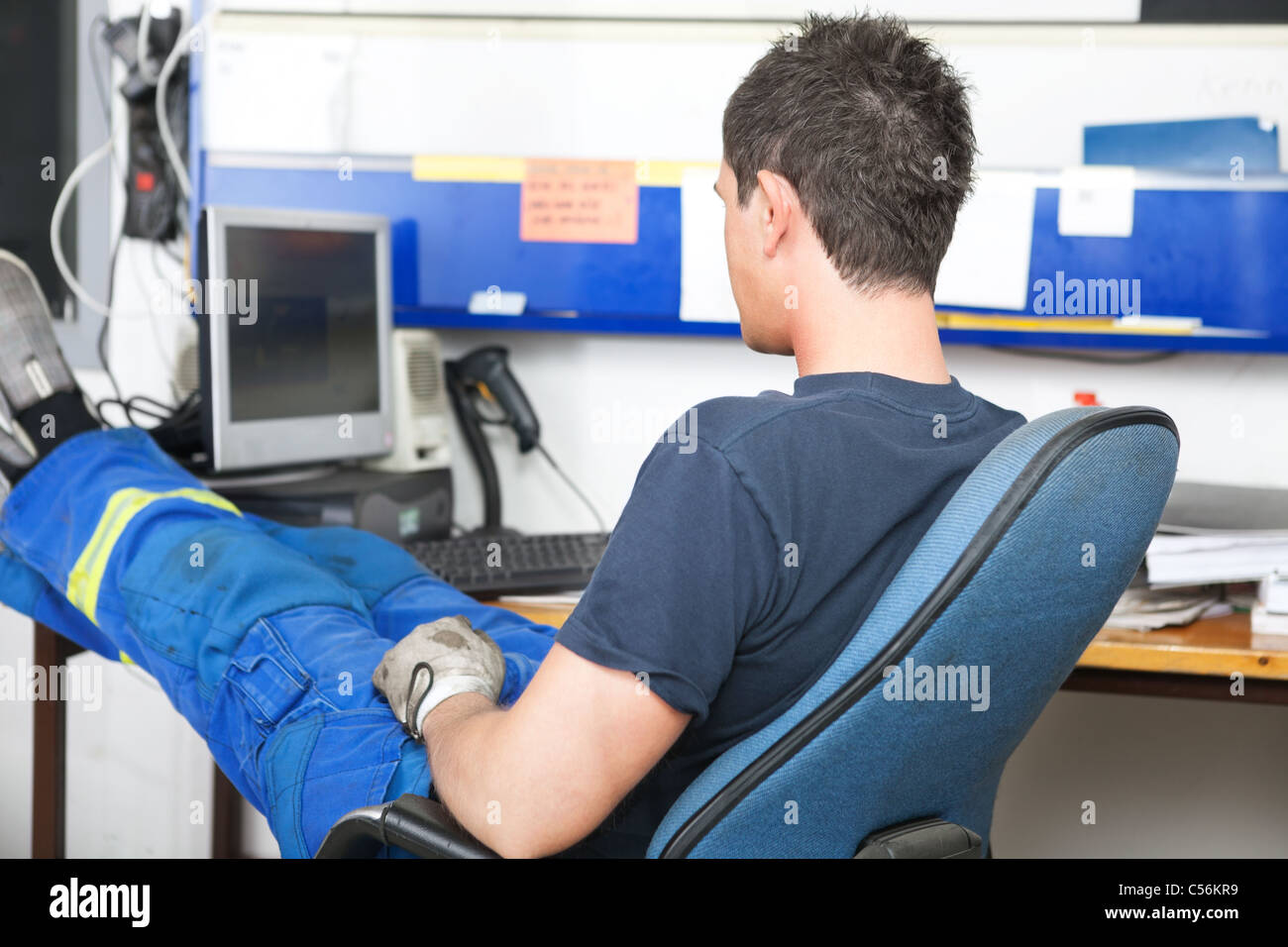 Mechanic sitting at desk in auto repair shop Stock Photo - Alamy