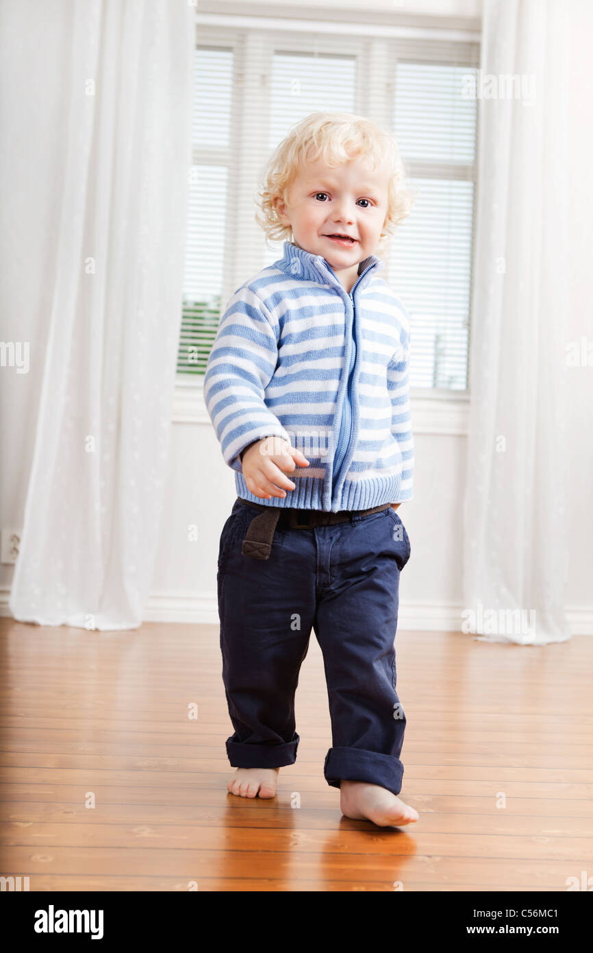 Full length of cute little boy walking on floor at home Stock Photo - Alamy