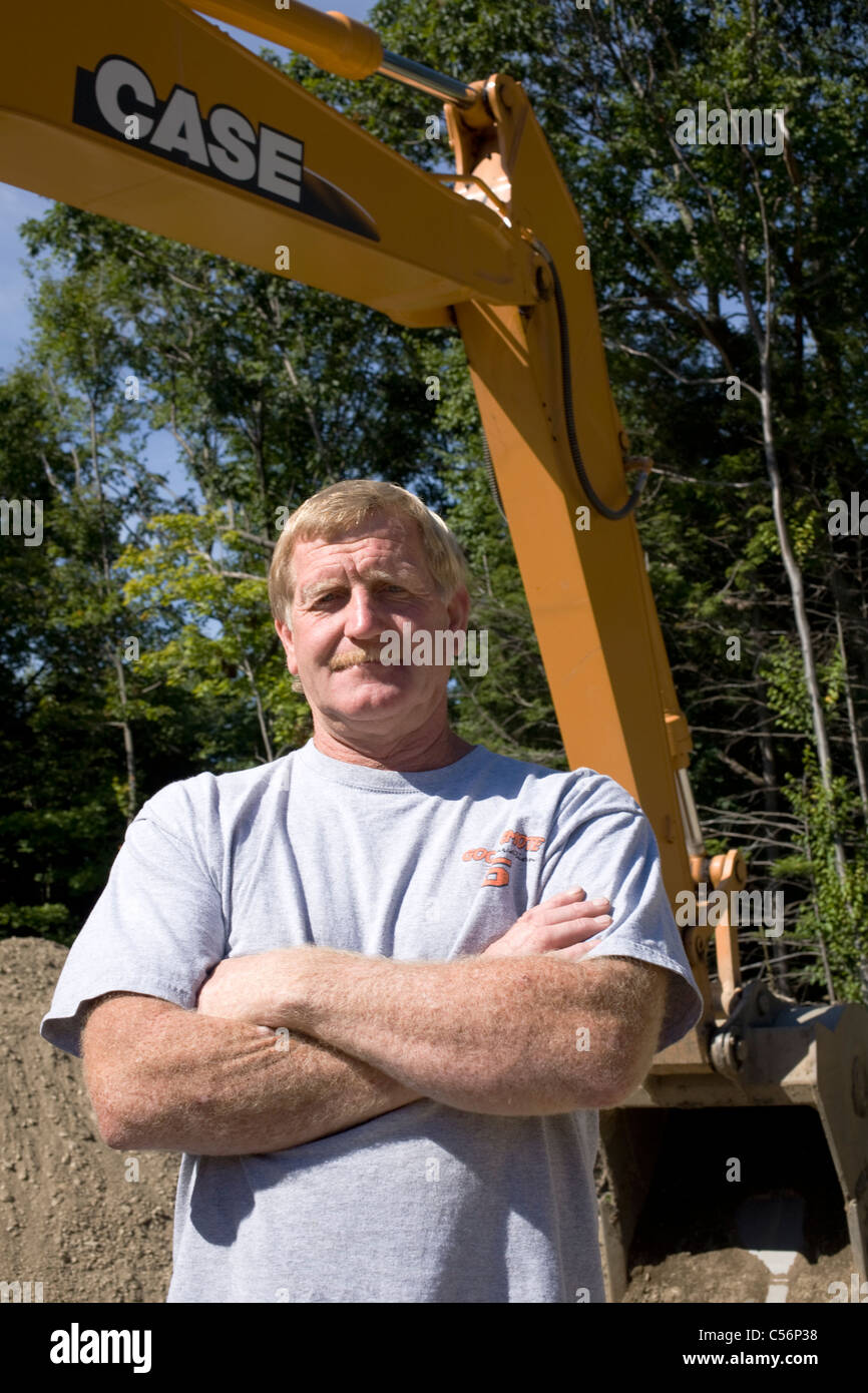 Backhoe driver stands proudly under the arm of his machine Stock Photo ...