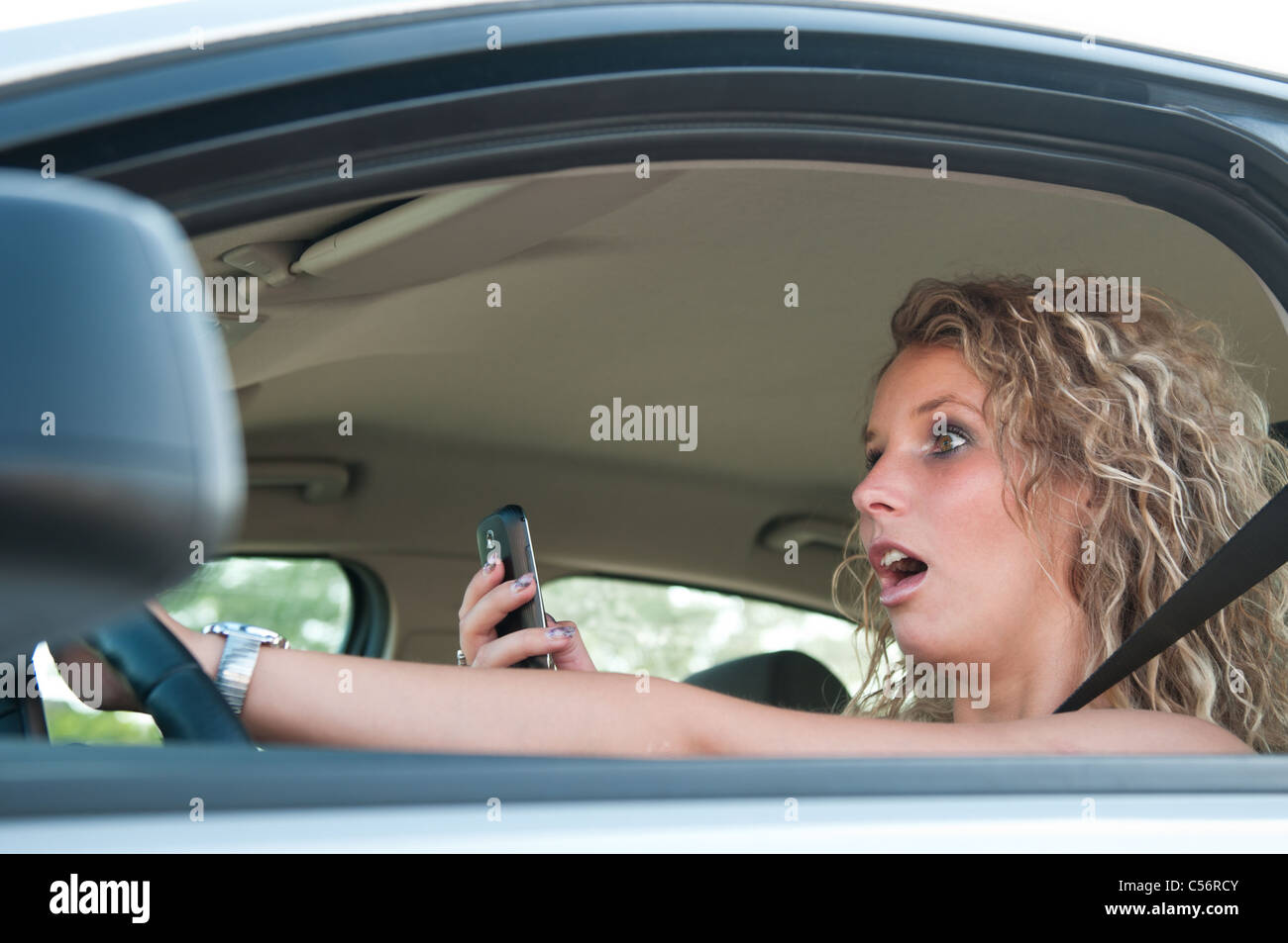Typing SMS while driving car Stock Photo - Alamy