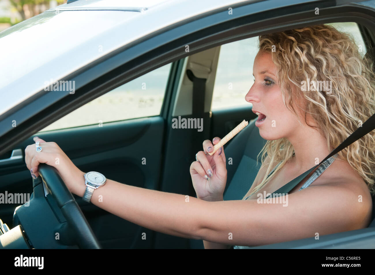 Woman eating while driving hi-res stock photography and images - Alamy