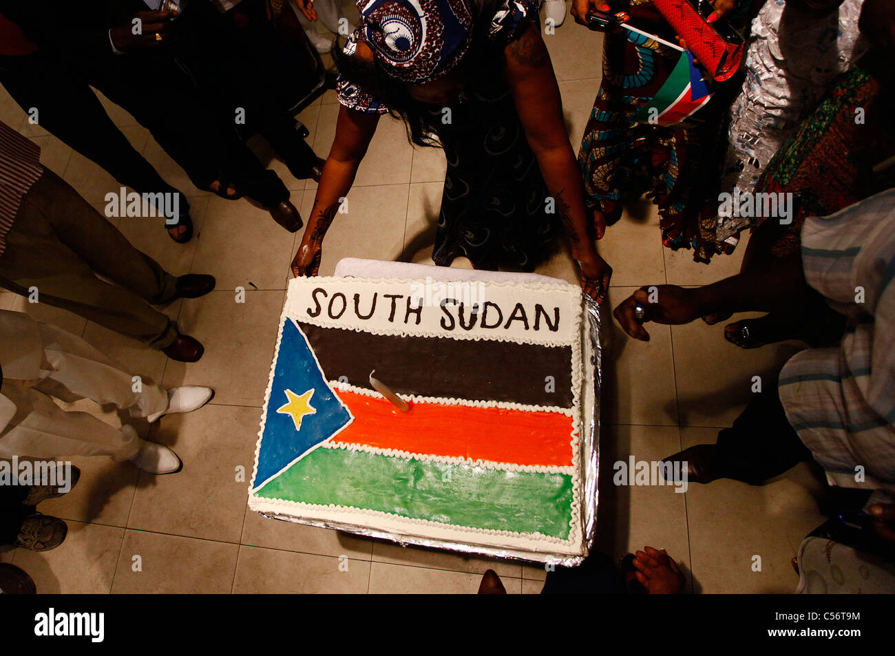 South Sudanese woman holds a Republic of South Sudan flag cake during ...