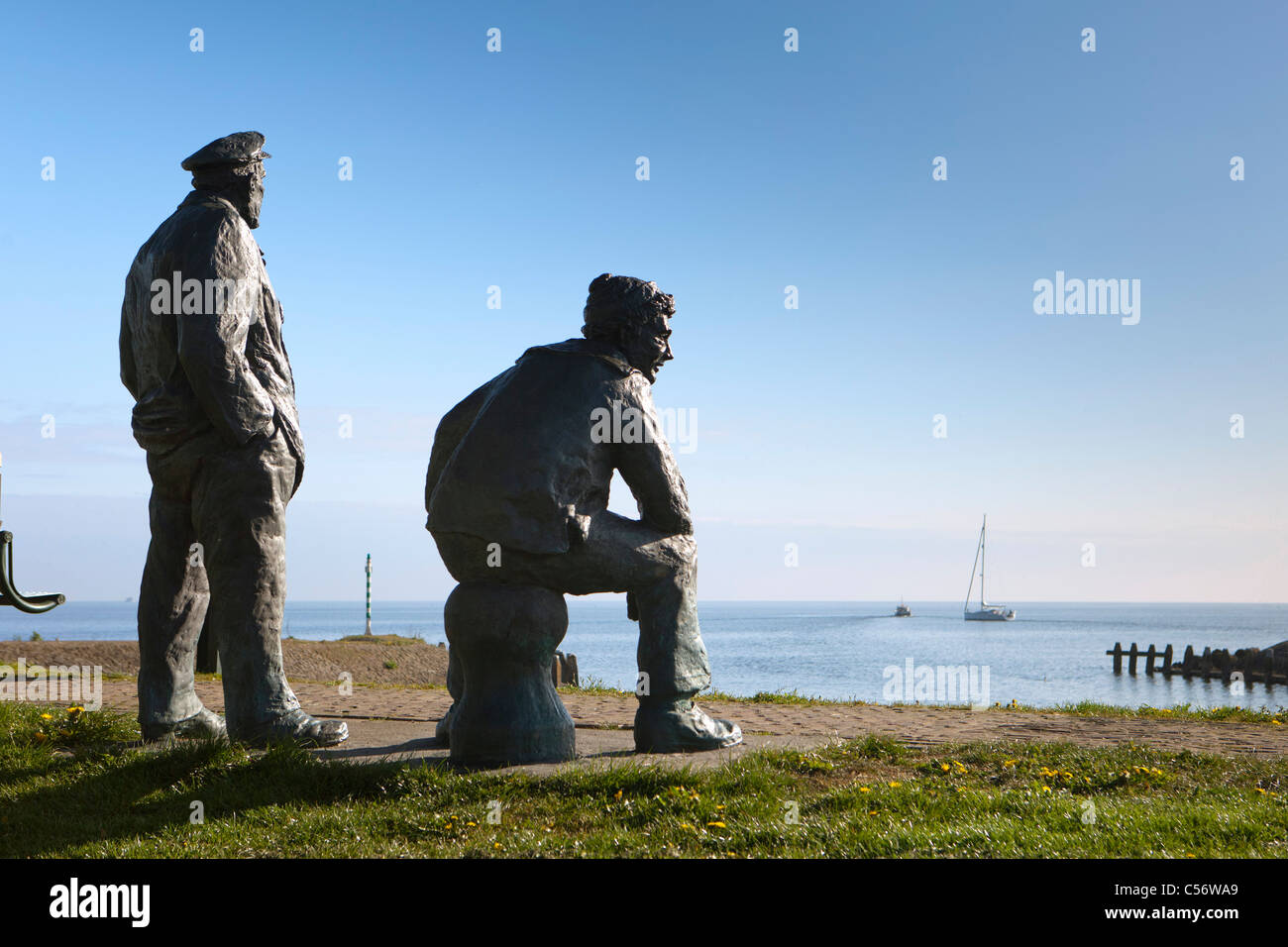 The Netherlands, Medemblik, Statues of fishermen in harbour Stock Photo ...