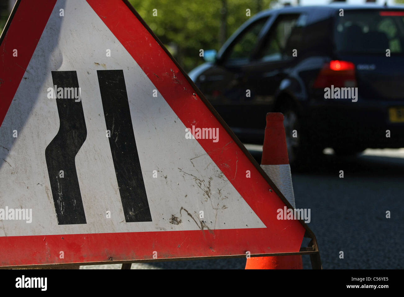 A close up of a road narrows sign with a vehicle passing Stock Photo ...
