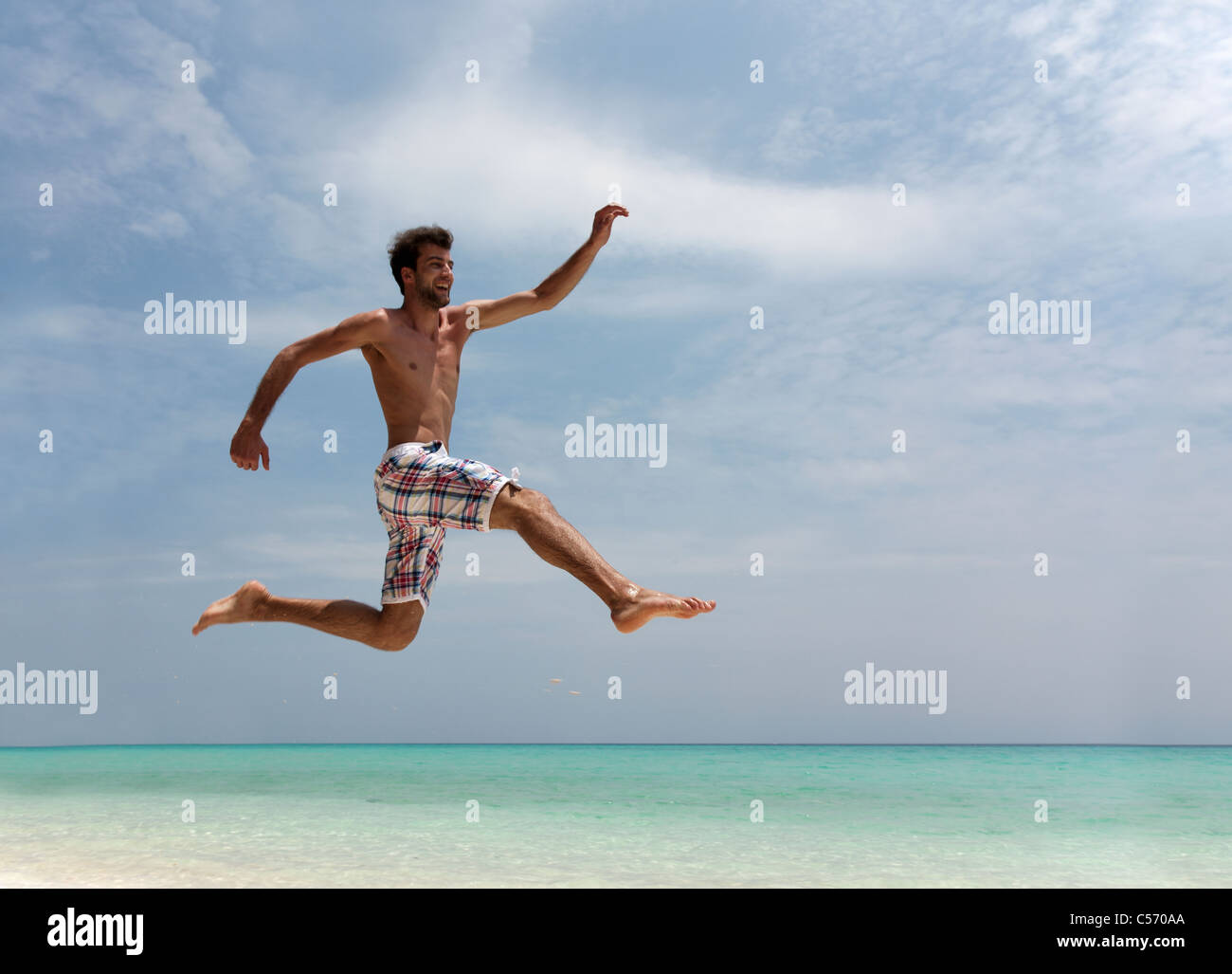 Man jumping on tropical beach Stock Photo - Alamy