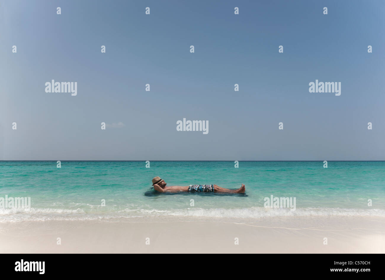 Man floating in water at tropical beach Stock Photo - Alamy