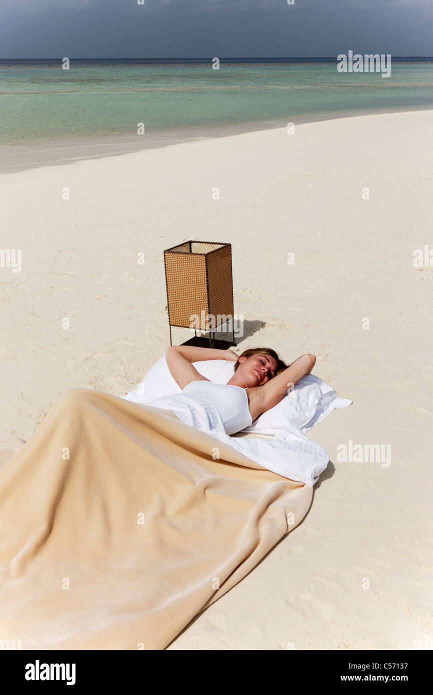Woman sleeping in bed on beach Stock Photo - Alamy