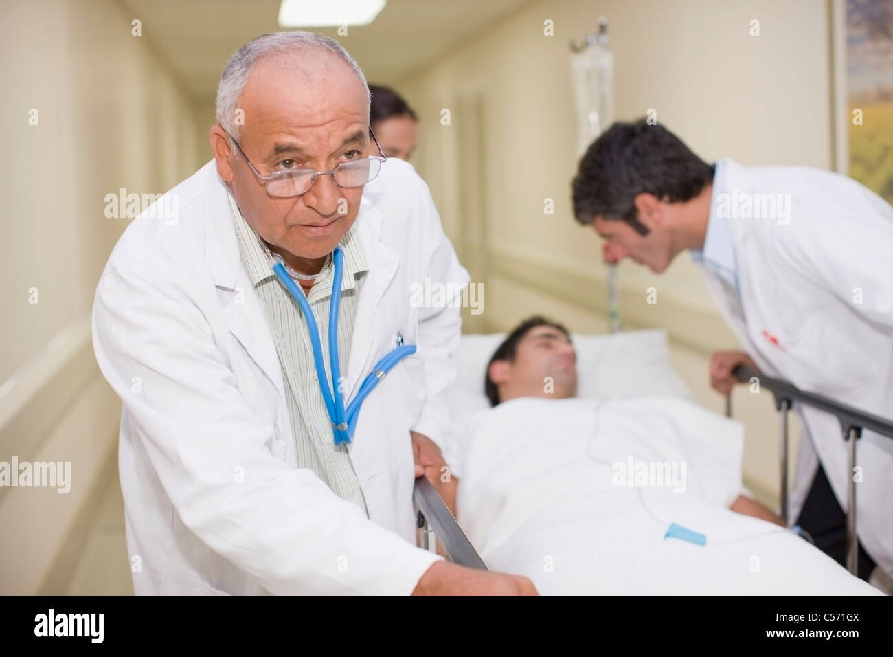 Doctors rushing patient down hallway Stock Photo - Alamy