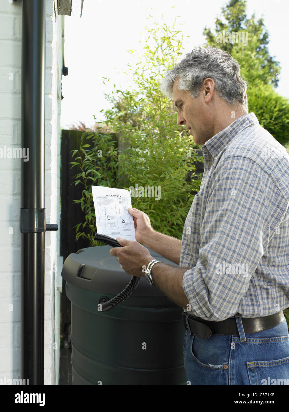 Man reading instructions in backyard Stock Photo - Alamy