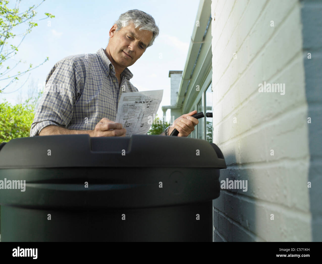 Man reading instructions in backyard Stock Photo - Alamy