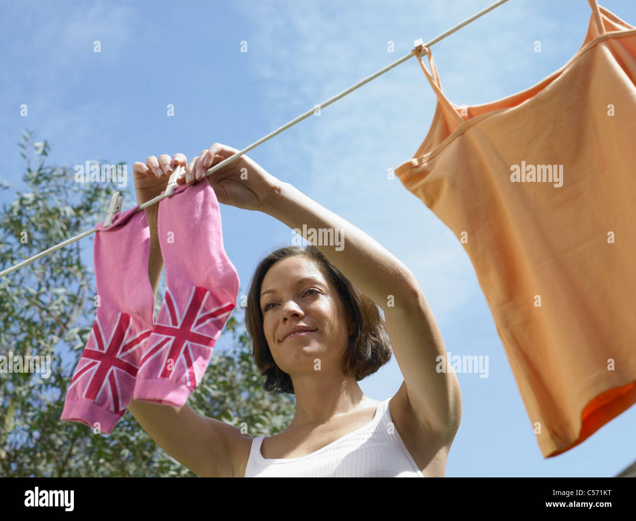 Woman hanging socks on clothesline Stock Photo - Alamy