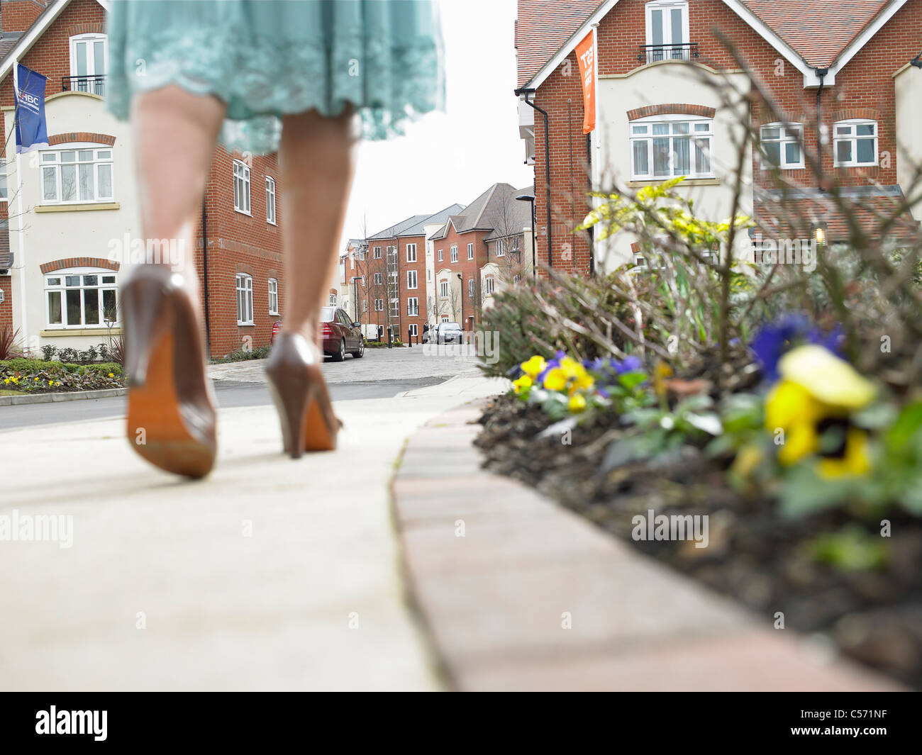 Woman walking on suburban street Stock Photo - Alamy