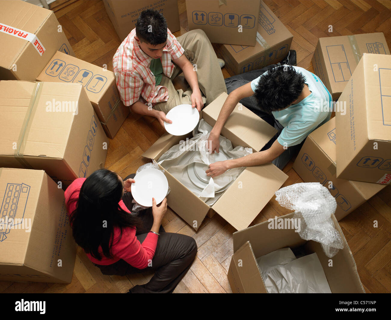 Family unpacking cardboard boxes Stock Photo - Alamy