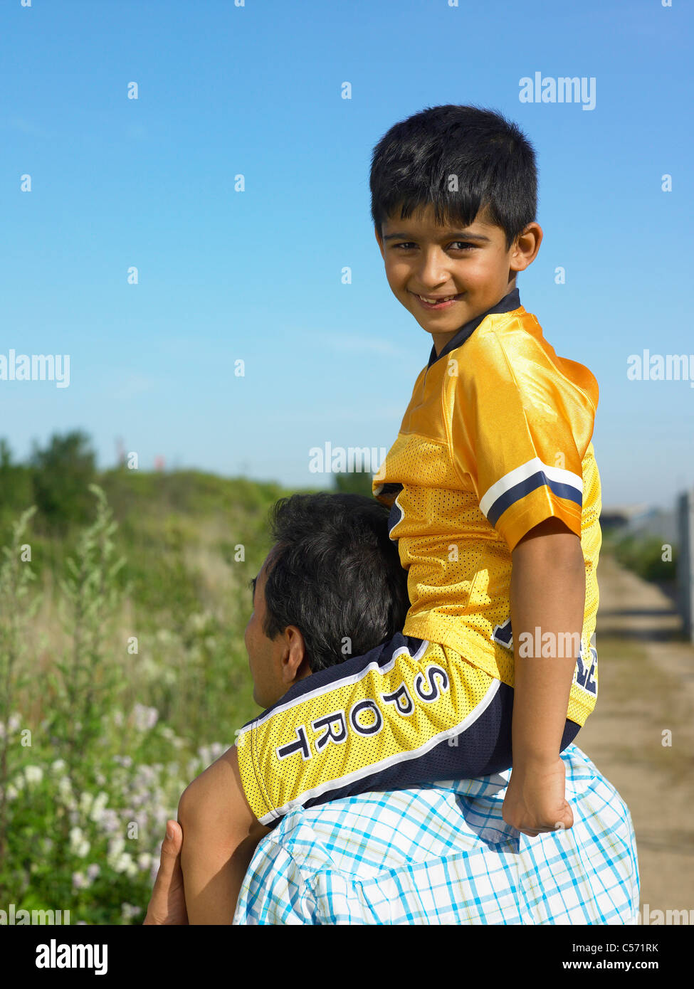Son sitting on father’s shoulders Stock Photo - Alamy