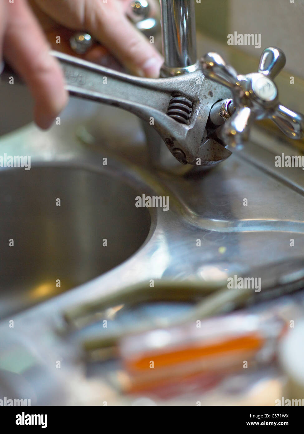 Man using wrench to fix faucet Stock Photo - Alamy