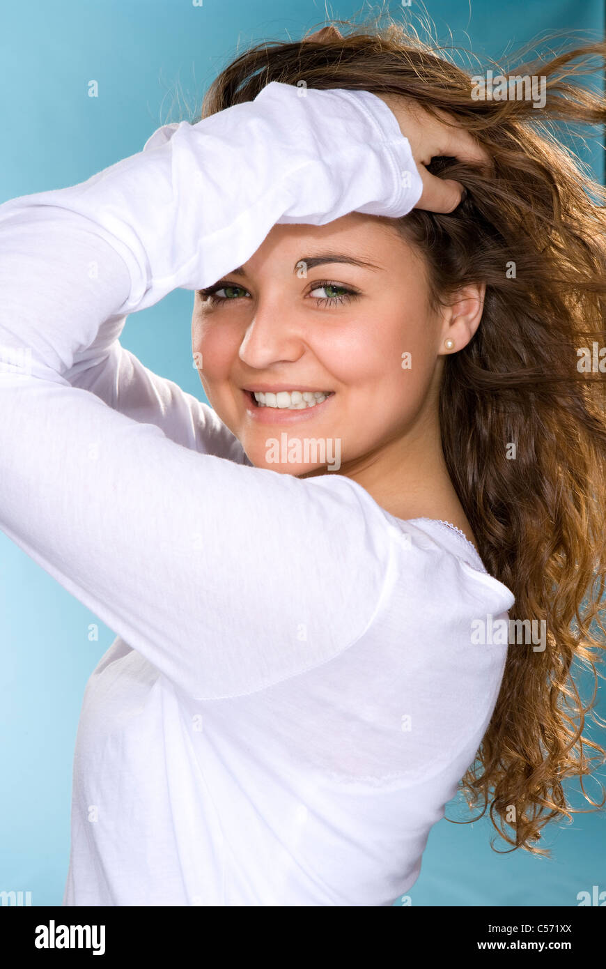 Woman smiling with hands in hair Stock Photo - Alamy
