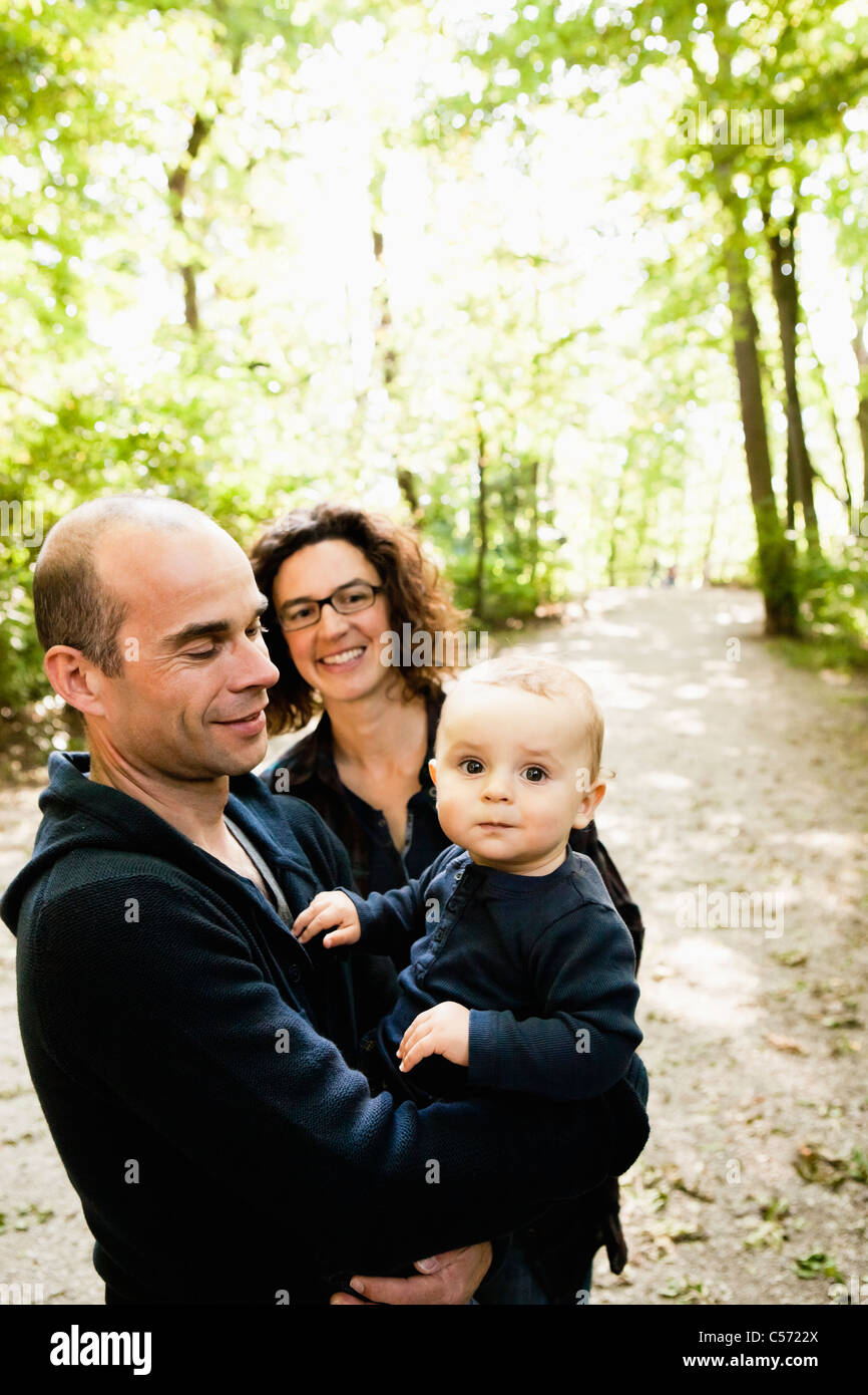 Parents carrying baby in park Stock Photo - Alamy