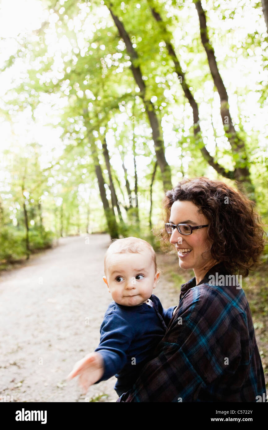 Mother carrying baby in park Stock Photo - Alamy