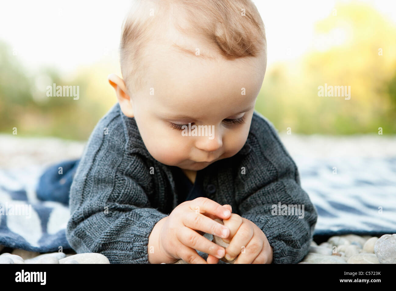 Baby playing with pebbles outdoors Stock Photo - Alamy