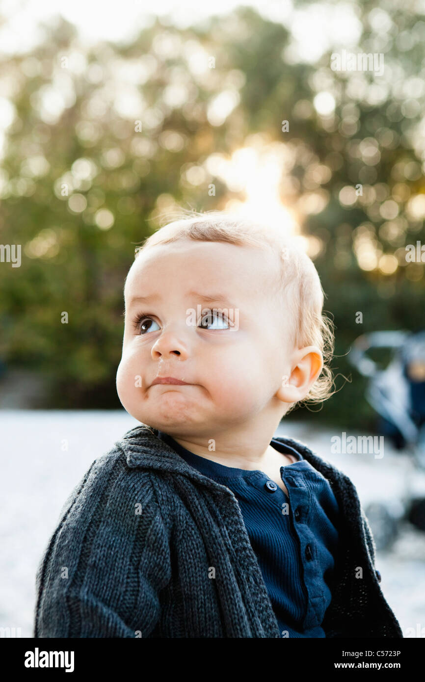 Scared baby sitting outdoors Stock Photo - Alamy
