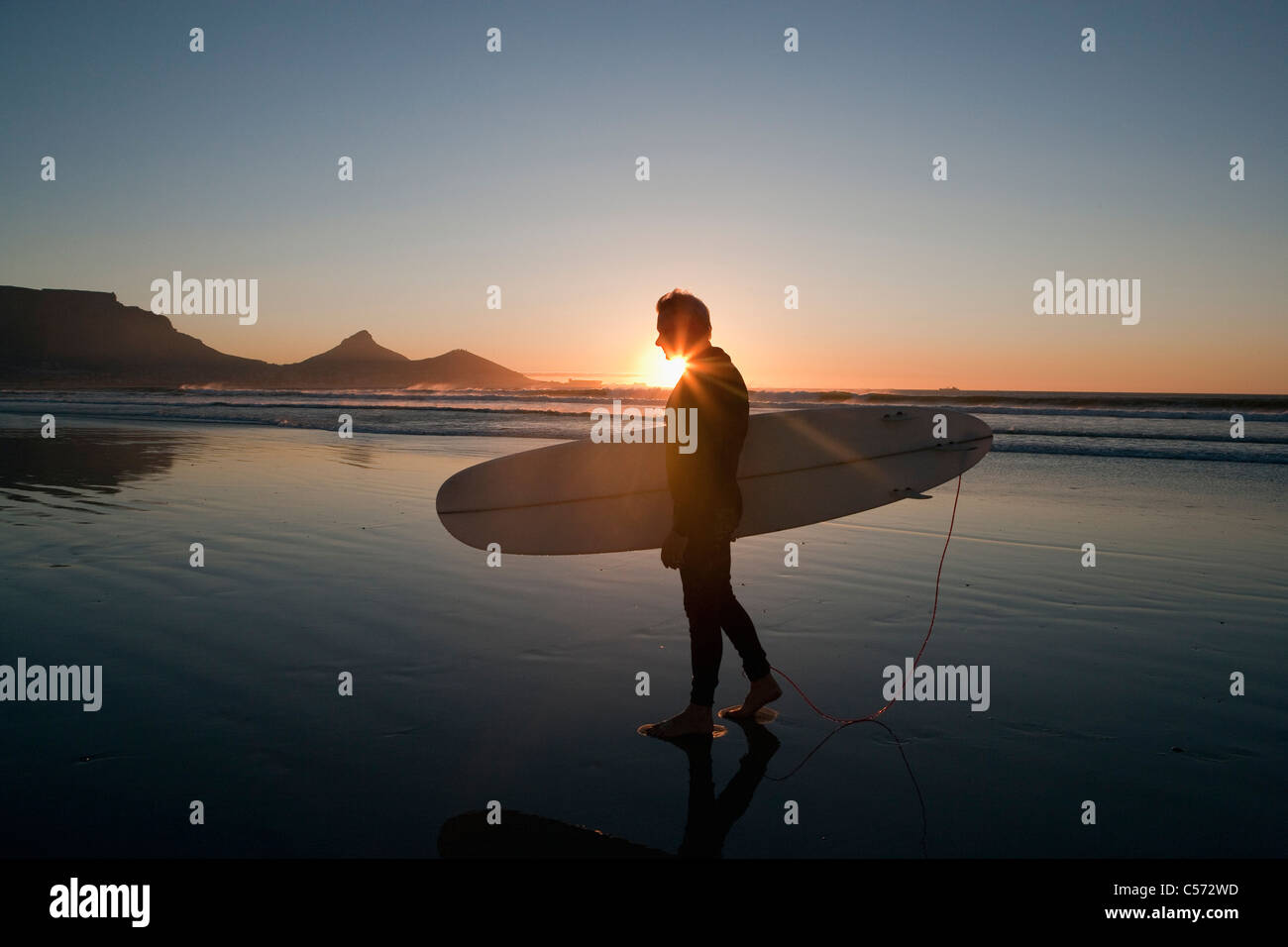 Surfer walking on beach Stock Photo - Alamy