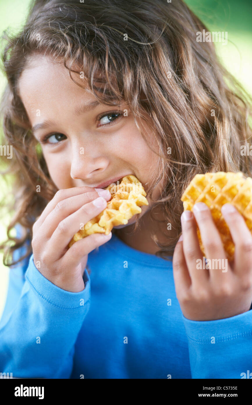 Smiling girl eating waffles Stock Photo - Alamy