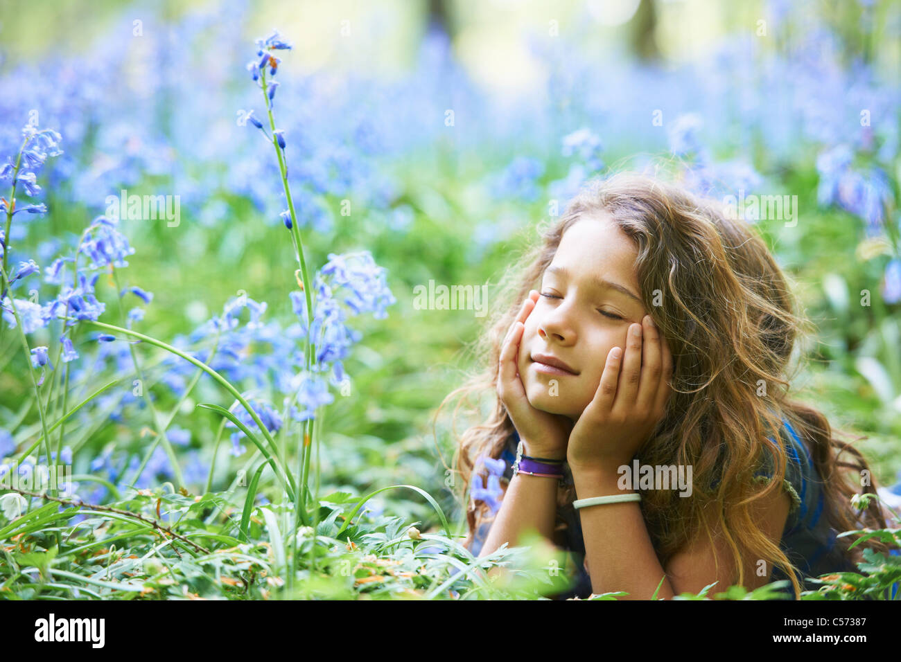Girl laying in field of flowers Stock Photo - Alamy