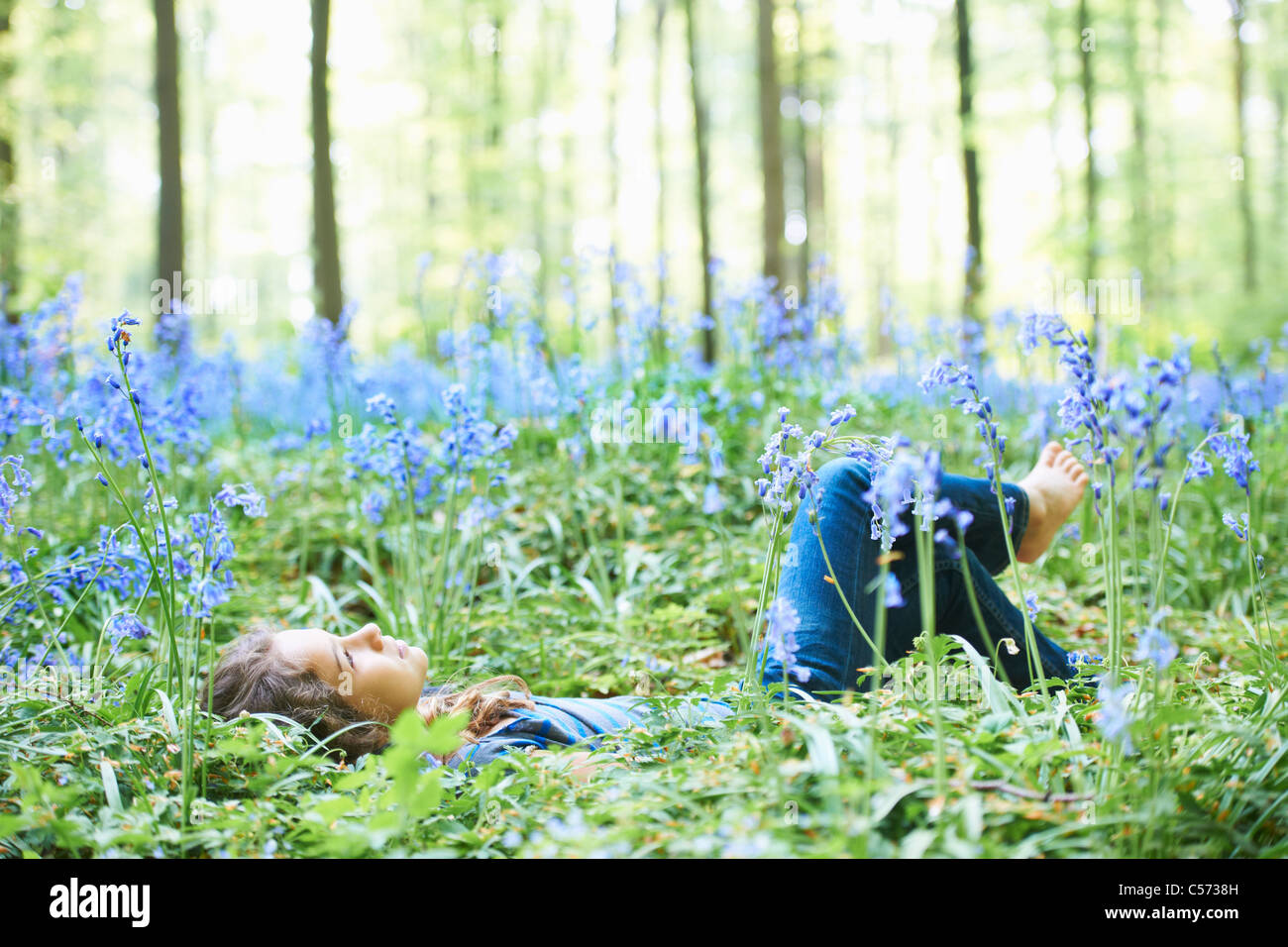 Girl laying in field of flowers Stock Photo - Alamy
