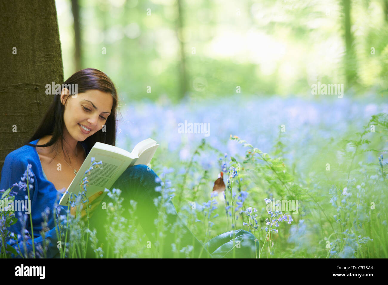 Woman reading in field of flowers Stock Photo - Alamy