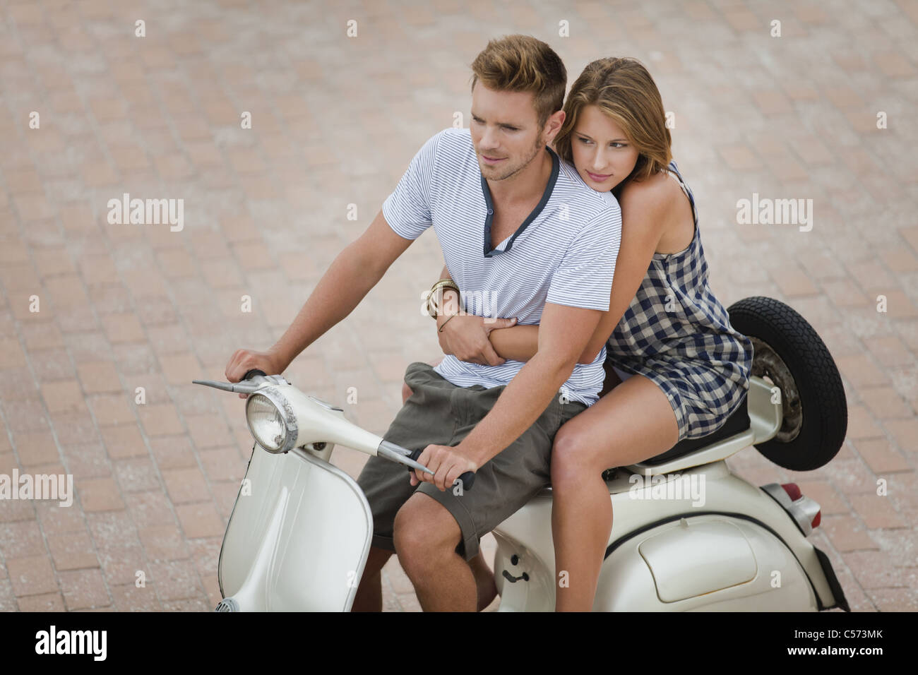 Couple riding scooter together Stock Photo - Alamy