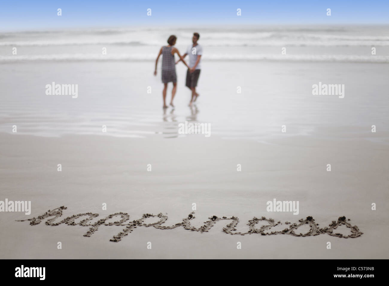 ‘Happiness’ in sand with couple on beach Stock Photo - Alamy