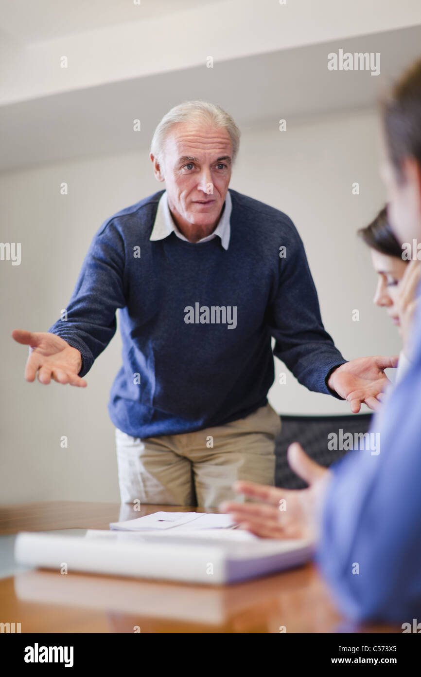 Businessman shrugging in meeting Stock Photo - Alamy