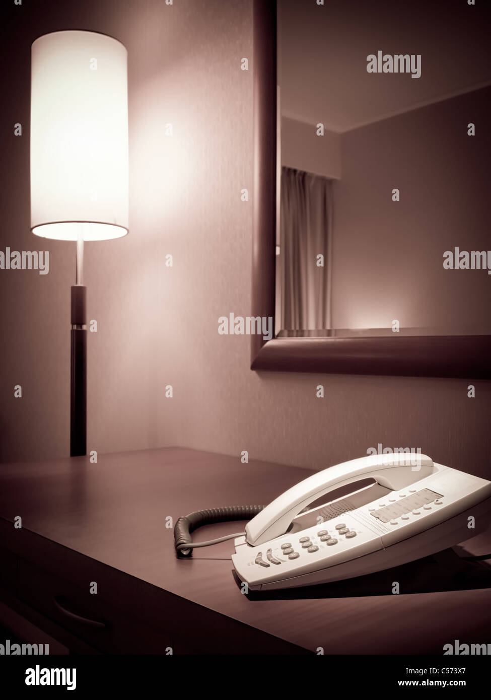Telephone on the desk in the bedroom lit with the lamp, toned image,for ...