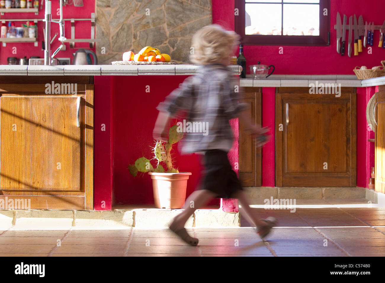 Boy running in kitchen Stock Photo - Alamy