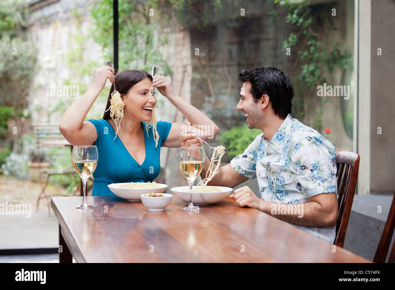 Playful couple eating together at table Stock Photo - Alamy