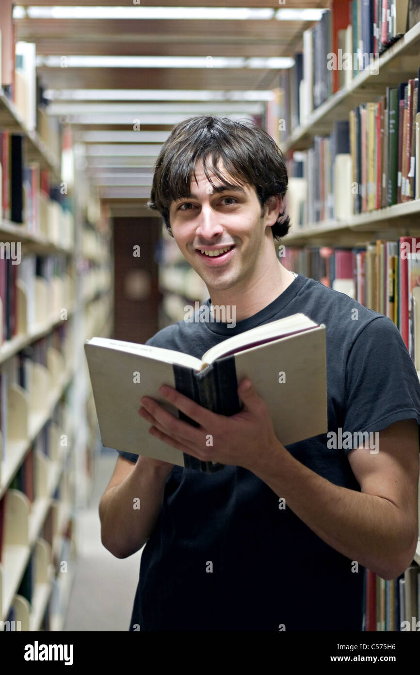 A young man reading a book at the library Stock Photo - Alamy