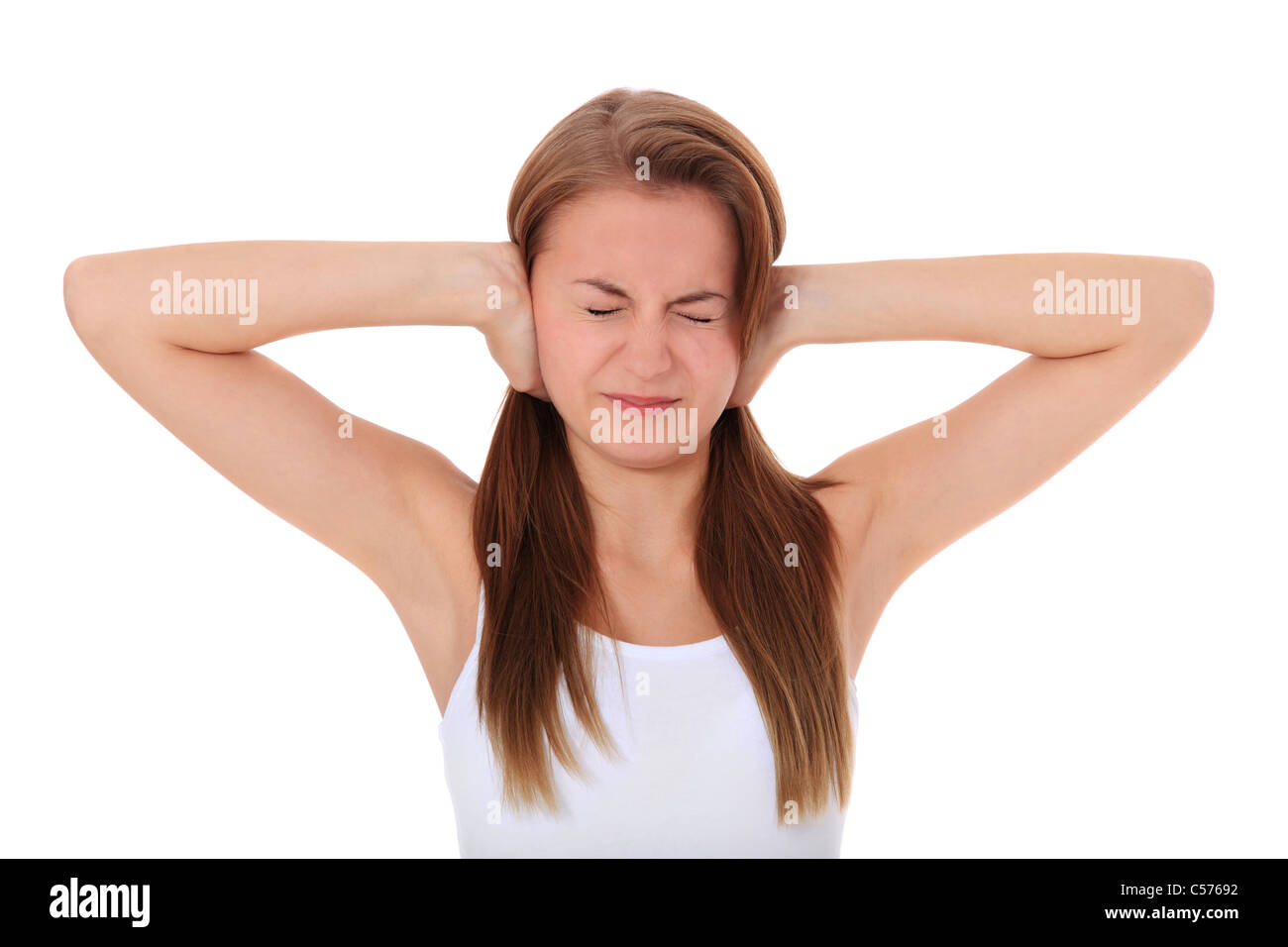 Attractive young woman keeps her ears shut. All on white background ...