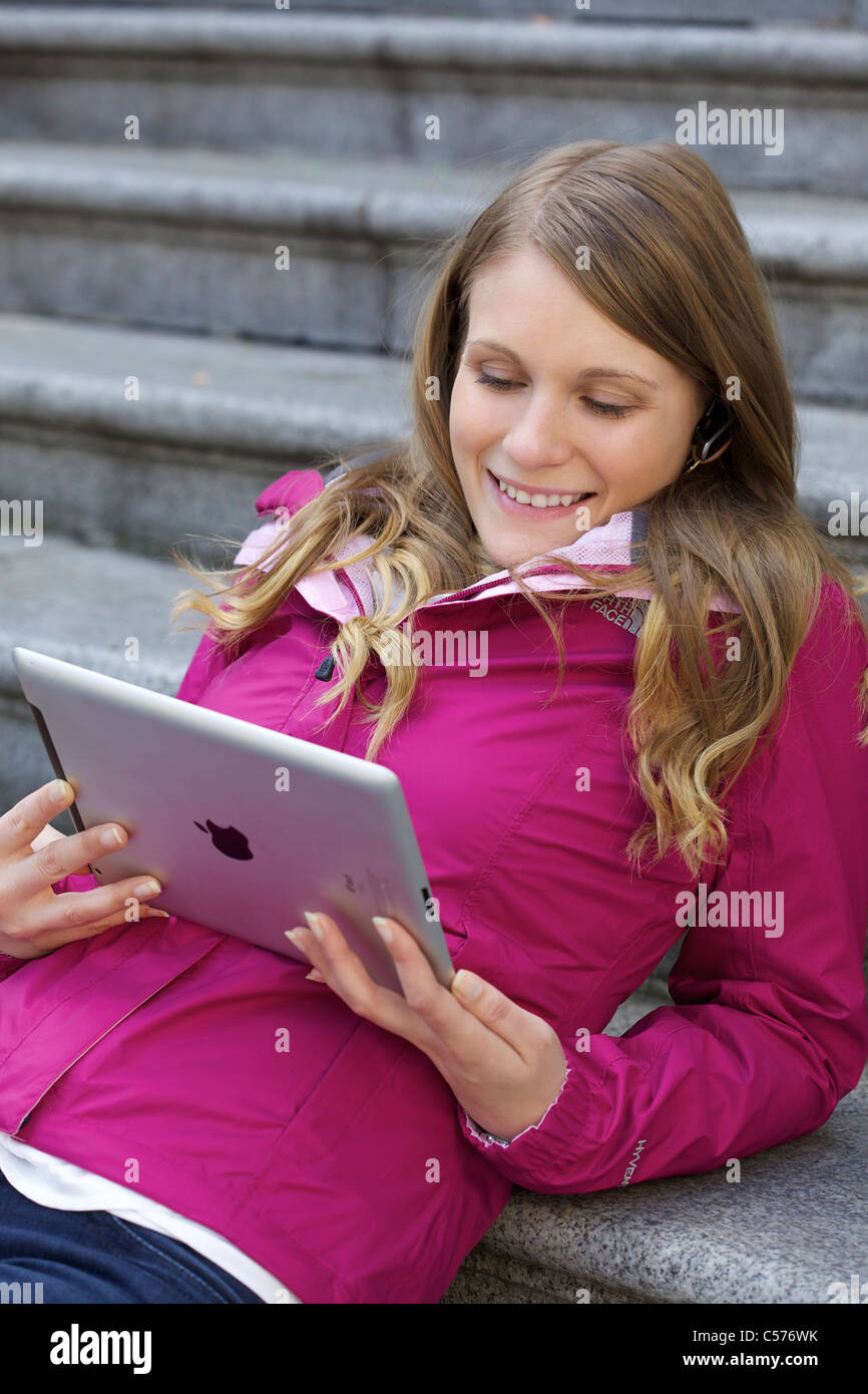 Beautiful young Caucasian woman reading on her iPad Stock Photo - Alamy
