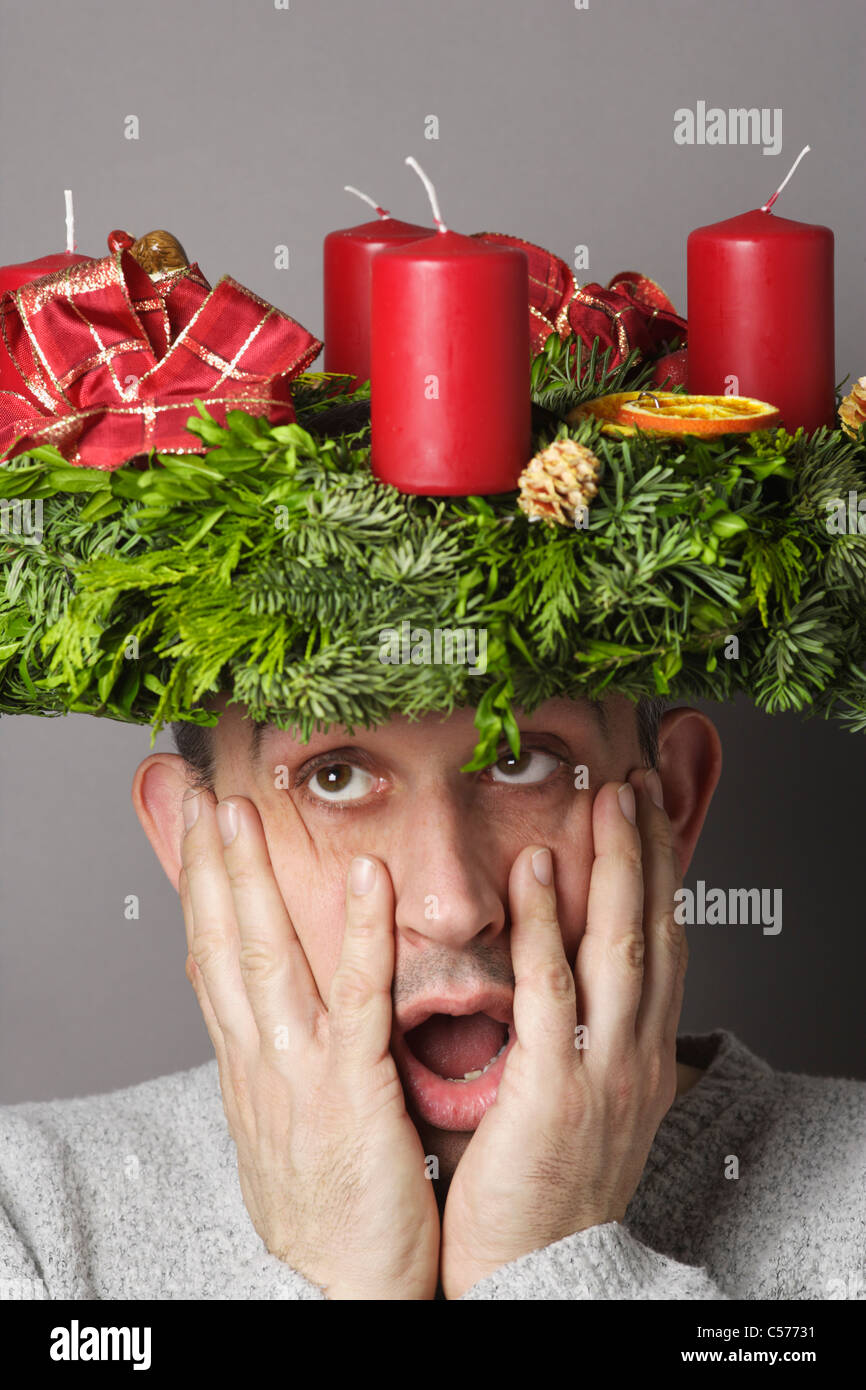 Man with advent wreath on his head. He is looking shocked and terrified ...
