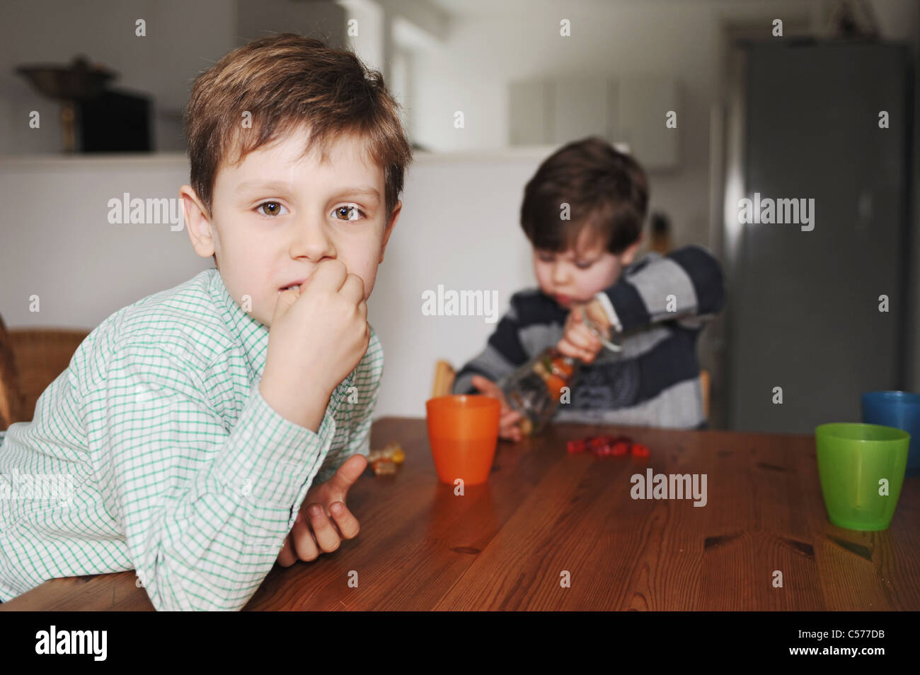 Boys playing with candy at table Stock Photo - Alamy