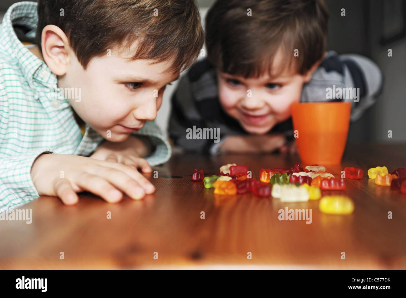 Boys playing with candy at table Stock Photo - Alamy