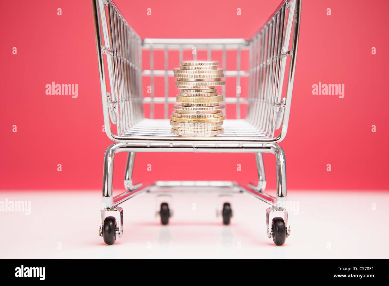Stack of coins in shopping cart Stock Photo - Alamy