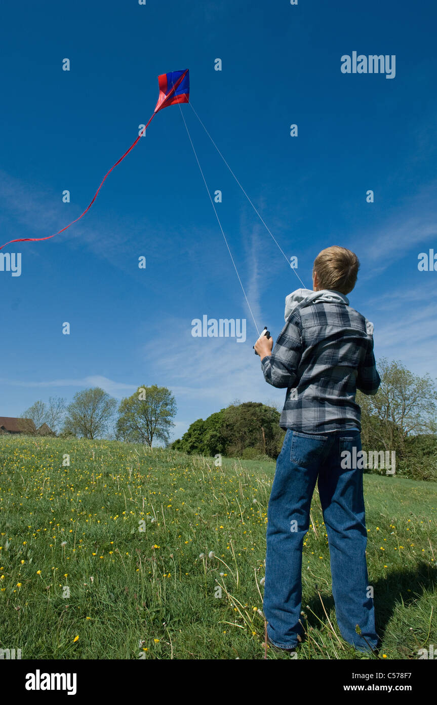 Boy flying a kite in field Stock Photo - Alamy