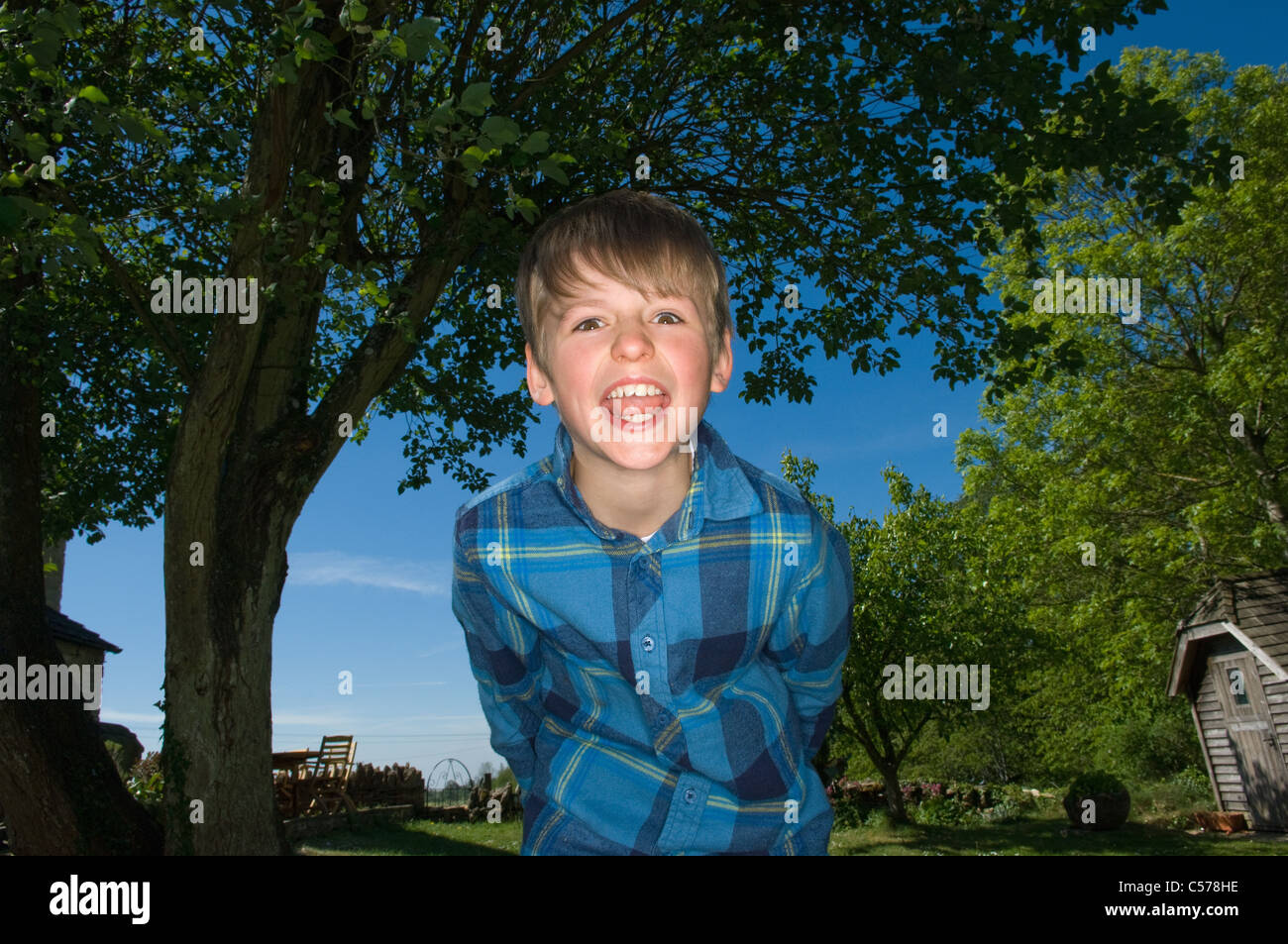 Boy shouting in backyard Stock Photo - Alamy