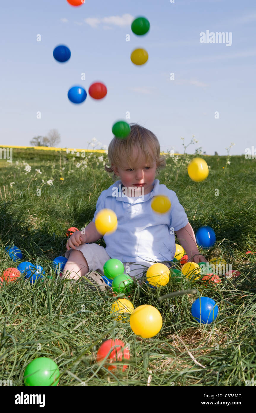 Toddler playing with colored balls Stock Photo - Alamy